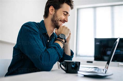 Software Developer Sitting In Front Of Computer And Working In Office Smiling Man Looking At