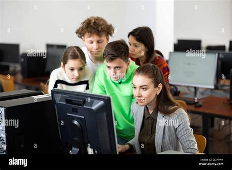 Female Teacher And Teen Babes Looking At Monitor Screen During Lesson Stock Photo Alamy