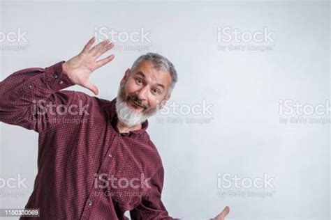 빨간 셔츠에 수염을 가진 성인 회색 머리 남자 미소와 흰 벽에 그의 팔을 파도 개념에 대한 스톡 사진 및 기타 이미지 개념