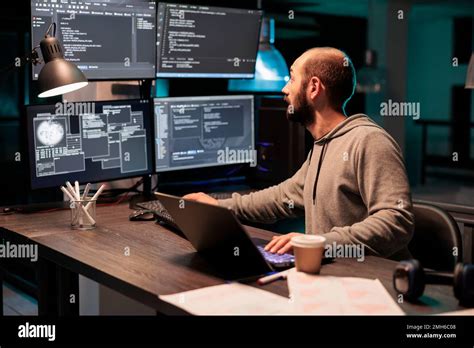 Software Developer Coding Database On Multiple Monitors To Program New