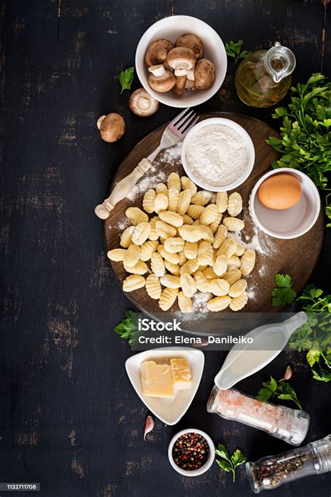 버섯 크림 소스와 파 슬 리가 있는 조리 되지 않은 홈메이드 그 레 치가 어두운 배경에 그릇에 있습니다 평면도 0명에 대한 스톡
