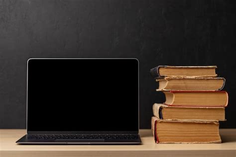 premium photo laptop and stack of books