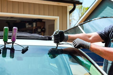 기술자는 특수 도구와 세부 사항에 대한 주의를 사용하여 낮 시간 동안 차고에서 자동차 앞유리를 수리합니다 45 49세에 대한 스톡 사진 및 기타 이미지 Istock
