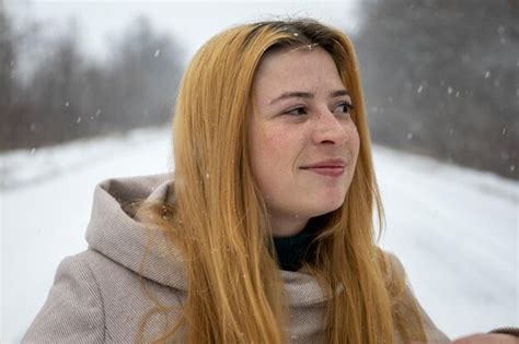 Retrato De Uma Menina Ruiva Com Sardas No Rosto Com Fundo De Neve Turva Foto Premium