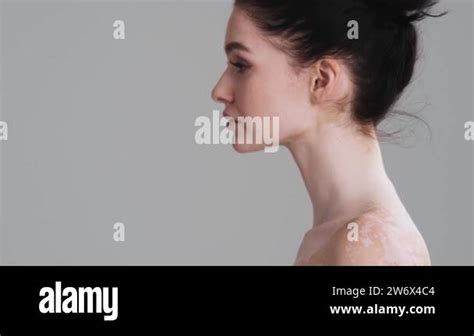 A Positive Half Naked Woman Is Turning Her Head To The Camera Standing Isolated Over Gray Wall