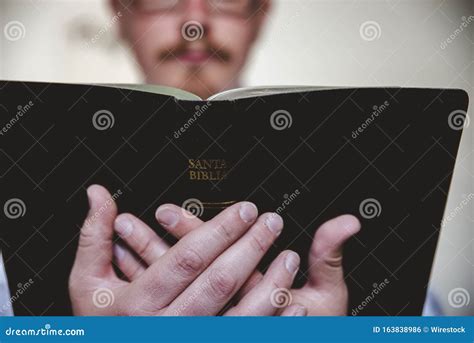 Closeup Shot Of A Male Reading The Bible With A Blurred Background