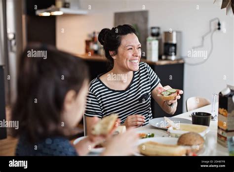 Lächelnde Mutter sitzt mit Tochter beim Frühstück beim Essen Tabelle Stockfotografie Alamy