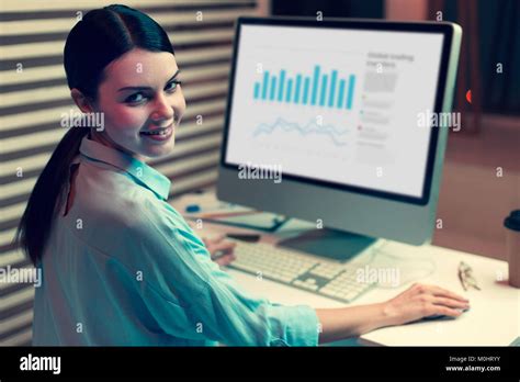 Pretty Woman Posing While Creating Graphs On Computer Stock Photo Alamy