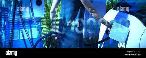 binary code on digital screen against woman charging electric car at