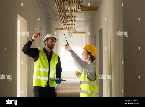 Male And Female Engineers Working On Construction Site They Are Monitoring The Building S