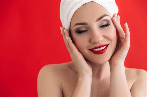 아름 다운 메이크업 웃는 화려한 소녀 화이트 치아와 붉은 입술 미소와 그녀의 머리에 수건 귀여운 여자의 클로 우즈 업 초상화 여 자가 웃 고 빨간 배경에 스튜디오 사진