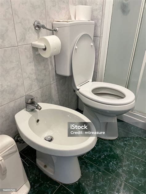 흰색 욕실 스위트 흰색 세라믹 비데 및 화장실 분리 슬라이딩이 있는 샤워 칸막이 패널 유리 도어 벽걸이 형 화장실 롤 홀더 녹색 대리석 효과 바닥 타일 전경에 초점을 맞춘