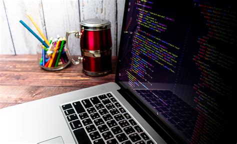 시스템 분석 및 디자이너가 설계한 대로 프로그래머가 웹 사이트 또는 모바일 앱으로 개발한 책상 위에 놓인 랩톱의 프로그램 소스