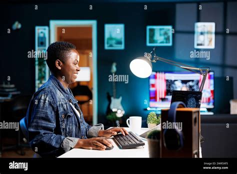 Smiling Black Woman Managing A Complex System Using Machine Learning On Her Personal Computer