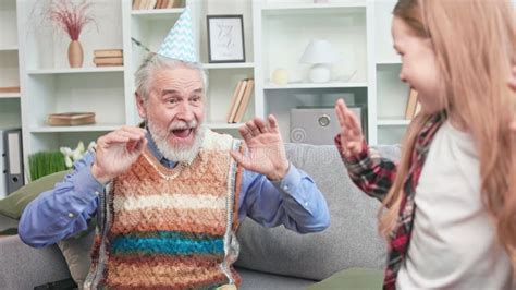 Excited Grandfather And Granddaughter Having Birthday Party Stock