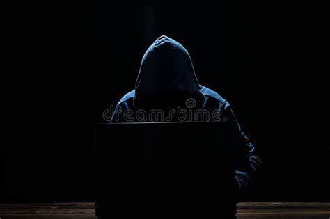 A Hacker With Laptop Sits At A Table And Abstract Binary Code Business