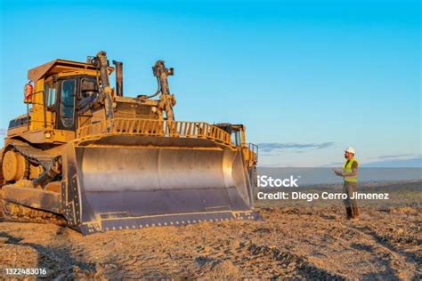 안전 헬멧과 무거운 기계 불도저를 검사 반사 조끼와 노동 검사관 건설 현장에서 대형 굴삭기 트랙터 고객 서비스 담당자에 대한 스톡 사진 및 기타 이미지 Istock