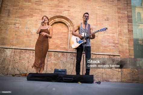 스페인 세비야의 바쁜 거리에서 노는 버스커 기타리스트 남자와 가수 여자 2명에 대한 스톡 사진 및 기타 이미지 2명 놀기 20 24세 Istock