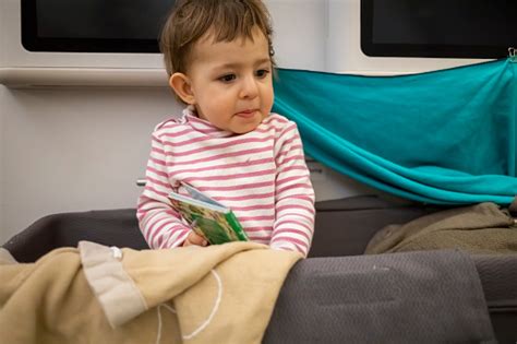 깜짝 놀란 표정으로 주위를 둘러보는 비행기의 아기 요람에 앉아있는 작은 귀여운 유아 경제에 대한 스톡 사진 및 기타 이미지 경제 교통수단 귀여운 Istock