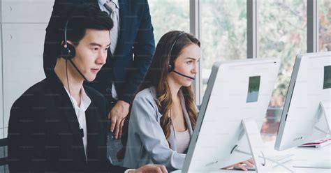 원격 고객 또는 동료를 지원하기 위해 사무실에서 일하는 헤드셋을 착용한 비즈니스 사람들 콜센터 텔레마케팅 고객 지원 상담원은 전화 화상 회의 서비스를 제공합니다 사진