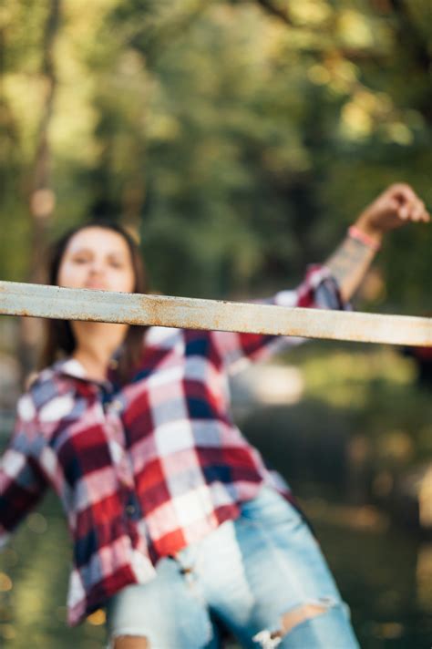 낮 동안 갈색 나무 울타리를 들고 있는 빨간색 흰색과 파란색 격자무늬 드레스 셔츠를 입은 남자 사진 Unsplash의 무료