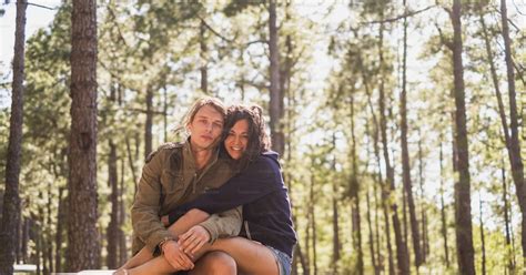 우정과 사랑이 여행 휴가 동안 차 지붕에 앉아 있는 커플 높은 소나무와 나무를 배경으로 숲에 주차되어 있습니다 자연과 야외 레저 활동을 즐깁니다 사진