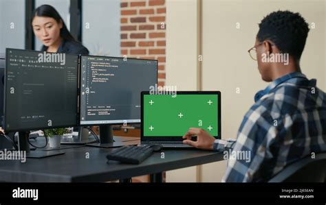 Database Designer Writing Code Using Laptop With Green Screen Chroma Key Mockup Sitting At Desk