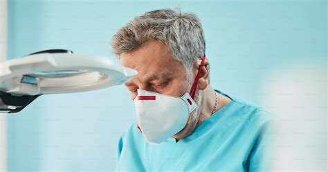 의료용 마스크와 장갑을 낀 성인 남성의 측면 모습 초상화는 미용 클리닉에서 전문 페디큐어를 수행합니다 사진 Unsplash의 휴식 이미지