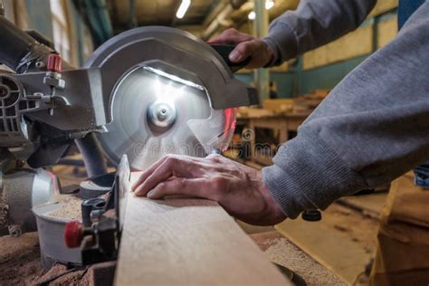 Carpenter Cutting Flaxboard Using Sliding Compound Mitre Saw Stock