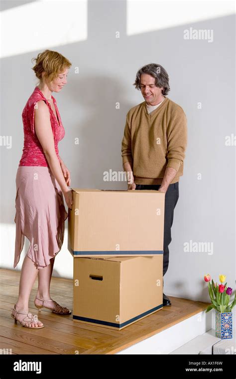A Couple Standing Next To Cardboard Boxes Stock Photo Alamy