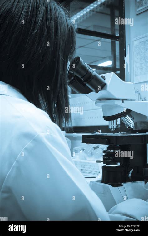 Serious Clinician Studying Chemical Element In Laboratory Microscope