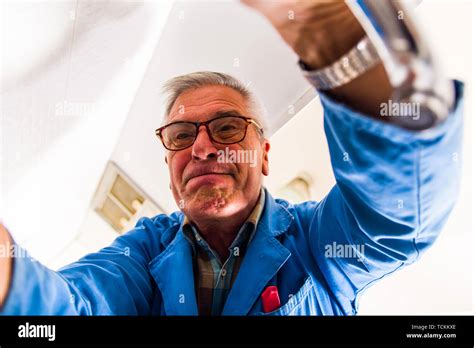 Old Male Repairman Is Holding His Tools And Working In The Kitchen Stock Photo Alamy