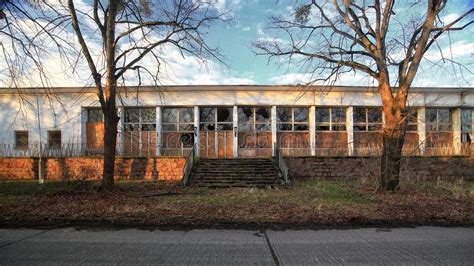 Deteriorating White Structure With Shattered Glass And Boarded