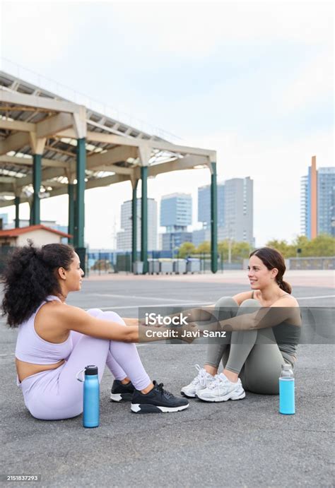 Vertical Photo Of A Two Sportswomen Friends Help Each Other Get Up From