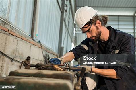 산업 공장의 전문 남성 엔지니어 유지 보수 선반 기계 안전 유니폼 고글 및 헬멧이 있는 선반 기계를 수리하는 엔지니어 20 24