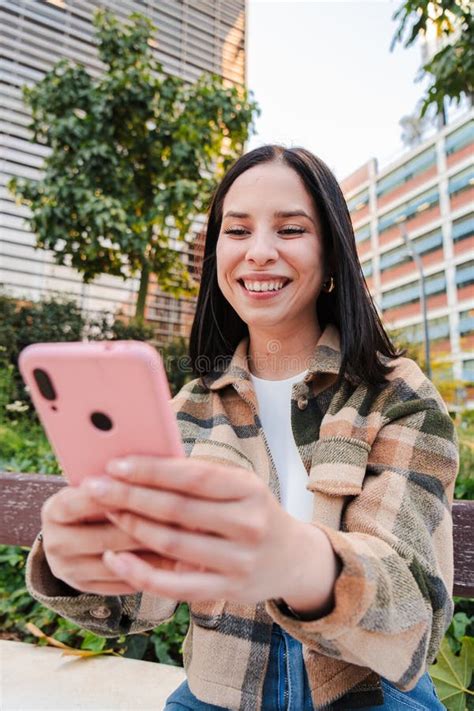 Vertical Young Hispanic Woman Texting And Sending Messages With A
