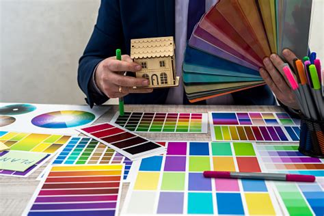 직장에서 견본 샘플 또는 카탈로그 팔레트 가이드에서 색상을 선택하는 정장그래픽 또는 인테리어 젊은 디자이너 테이블에 페인트 색상 팔레트 샘플 그래픽 디자이너 Cmyk에 대한