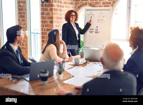 Group Of Business Workers Smiling Happy And Confident In A Meeting Working Together Looking At