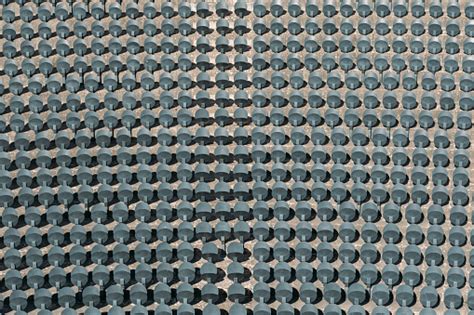 대형 야외 경기장의 스탠드에 있는 회색 접이식 좌석 평면도 좋아하는 팀의 팬을 위한 좌석입니다 스포츠 경기장 및 바닥에 장착되는 홀을 위한 빈 플라스틱 의자 가구에 대한