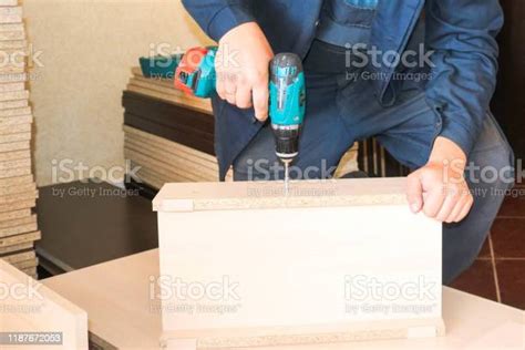 손에 드라이버를 들고 일하는 작업복을 입은 한 남자가 가구를 조립하고 있다 아파트 전문 수리 Diy에 대한 스톡 사진 및 기타 이미지 Istock