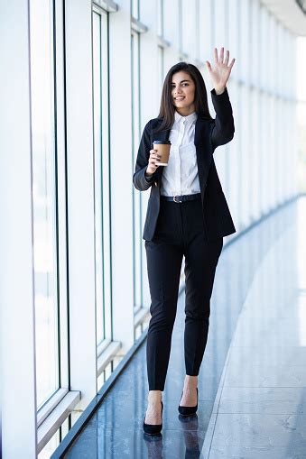 테이크 아웃 커피를 즐기고 인사를 하는 젊은 사업가 카메라에 손으로 손을 흔들고 판지 컵 행복 한 여자 커피 휴식 및 몸짓 개념 경영자에 대한 스톡 사진 및 기타 이미지