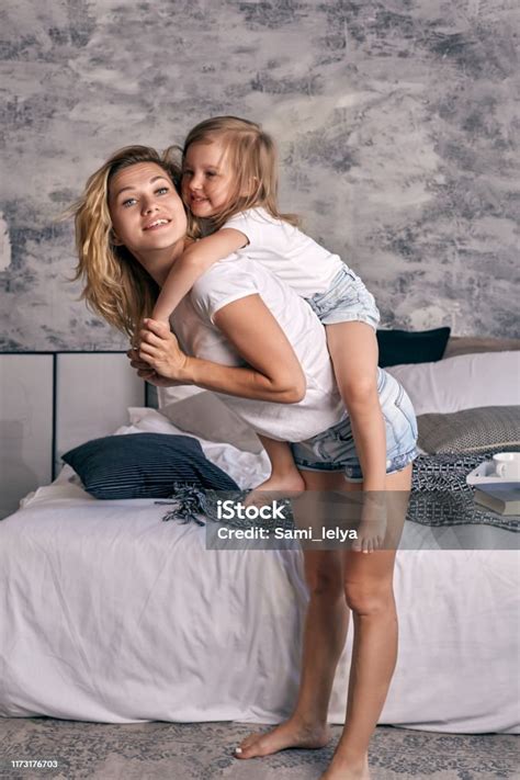 어머니와 그녀의 딸 아이 소녀 재생 및 포옹 사랑스러운 젊은 어머니는 웃고 귀여운 재미있는 아기 딸을 껴안고 집에서 함께 시간을 즐기고 있습니다 가정의 방에 대한 스톡 사진