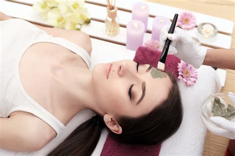 닥터 뷰티 살롱에서 젊은 여자의 얼굴에 막대기로 마스크를 적용 하는 클렌징과 피부 보습의 절차에 대 한 미용사입니다 미용 하 고 전문 피부 관리입니다 가꿔주기에 대한 스톡