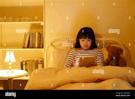 Girl Operating Tablet In Bed Stock Photo Alamy