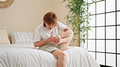 Middle Age Woman Smelling Dirty Feet At Bedroom Stock Photo Image Of Pajamas Feet