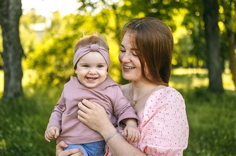 한 젊은 어머니가 한 살 짜리 아기와 함께 걷고 그를 품에 안고 안고 있다 그의 조화로운 발전을위한 아이와의 의사 소통 12 17 개월에 대한 스톡 사진 및 기타 이미지
