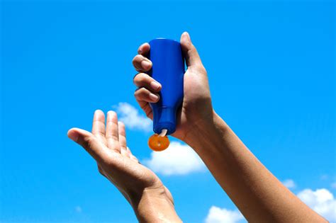 선스크린을 들고 있는 여성의 손 매우 태양 빛 하늘 배경입니다 건강 컨셉과 스킨 케어 개념에 대한 스톡 사진 및 기타 이미지 개념 건강관리와 의술 계절 Istock