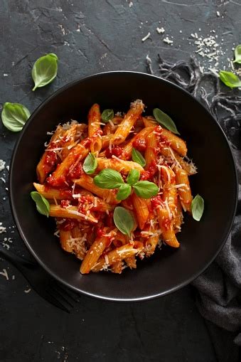 토마토 소스를 곁들인 페네 파스타 파마산 치즈 바질을 다크 백고운드에 얹어 먹습니다 건강한 식생활에 대한 스톡 사진 및 기타 이미지 건강한 식생활 검은색 녹색