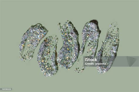 반짝이는 투명한 젤의 화장품 견본 얼굴 몸 머리카락을위한 실버 반짝이 올리브 배경에 축제 메이크업을 위한 반짝이는 화장품 질감 젤 평면도 스파클 번짐 0명에 대한 스톡 사진