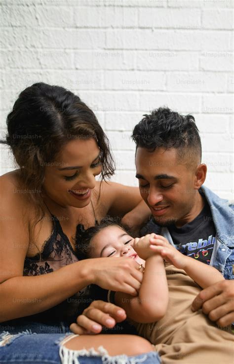 한 남자와 한 여자가 아기와 함께 침대에 앉아 있다 사진 Unsplash의 여자 이미지